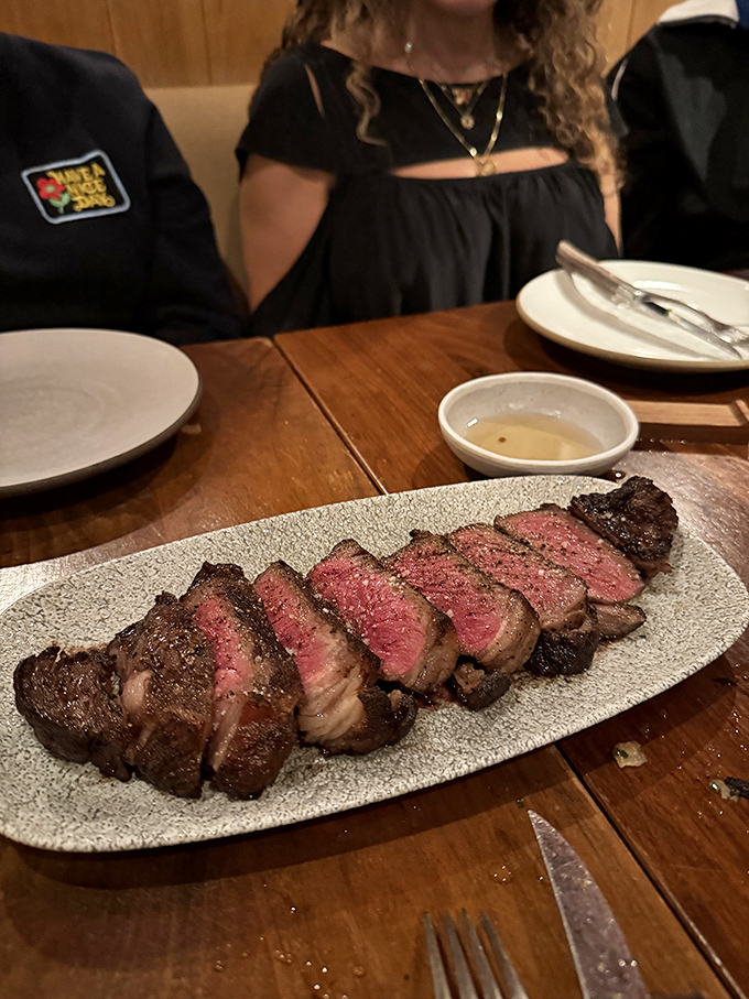 Behold the star of the show: perfectly medium-rare ribeye, sliced for sharing but tempting enough to keep all to yourself.