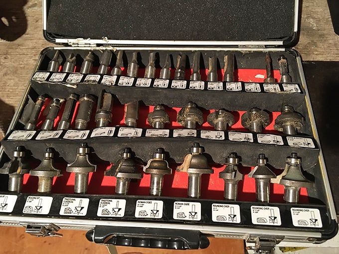A router bit collection that would make any woodworker weep tears of joy, all organized like a beautiful mechanical symphony.