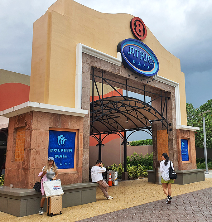 Entrance number 8 welcomes shoppers with its distinctive architecture and Dolphin Mall signage. The suitcase suggests someone found exactly what they came for.