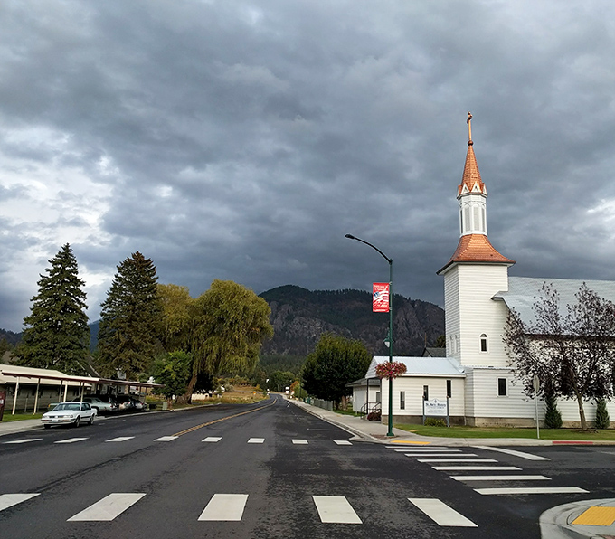 Chewelah's church steeple stands sentinel against dramatic skies &ndash; small-town spirituality with a backdrop worthy of a Hollywood epic.