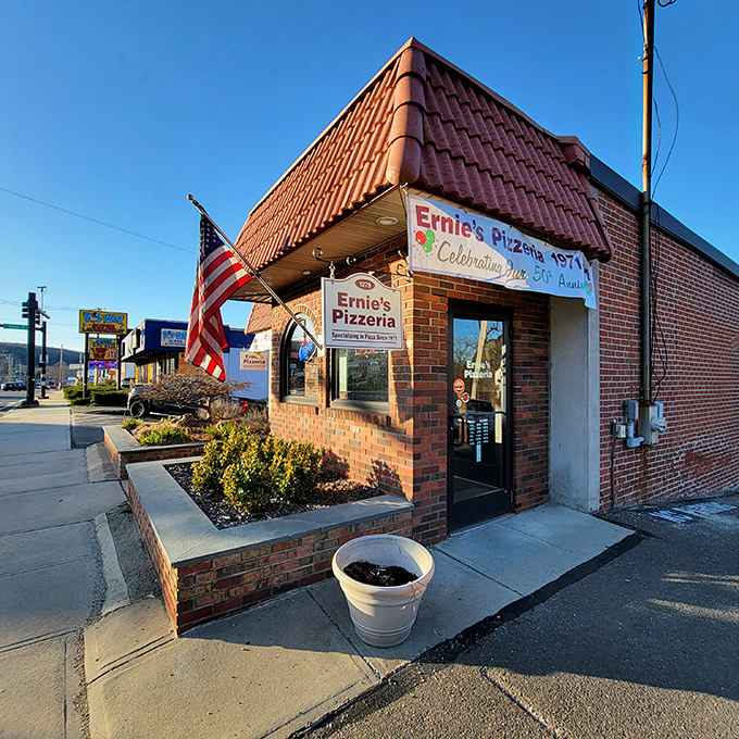 Ernie's distinctive red-tiled roof has sheltered pizza dreams since 1971. That American flag waves proudly over some of New Haven's finest crusts.