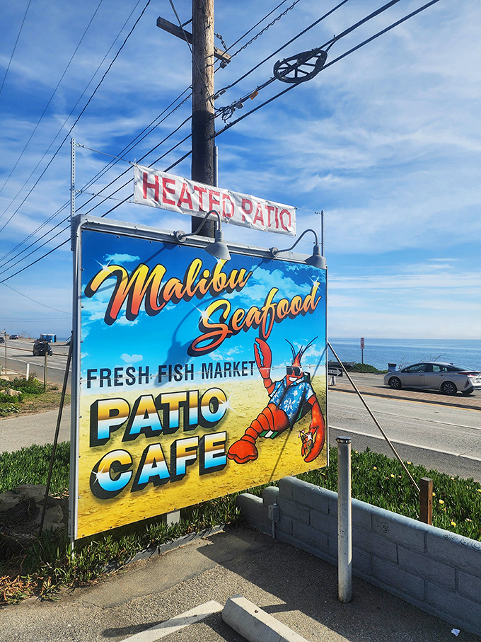 Malibu Seafood's colorful sign promises a heated patio and ocean views. That lobster looks happier than most Malibu residents!