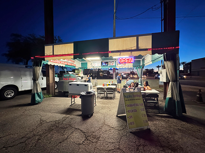 As night falls, Nogales Hot Dogs transforms an ordinary parking lot into a street food paradise under string lights.