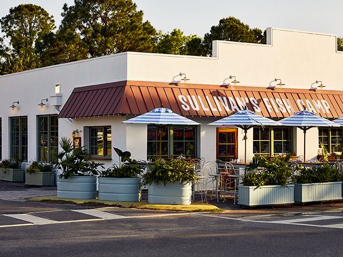 Sullivan's Fish Camp's crisp white exterior and red roof pop against the coastal sky. Beach house vibes with seafood that makes you want to move in permanently.