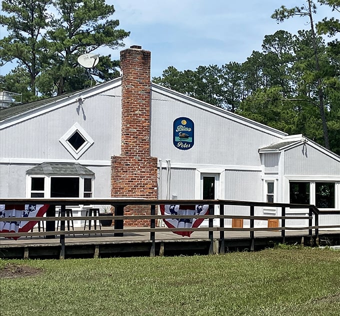 That brick chimney and wooden deck promise the kind of laid-back meal where time slows down and worries float away.