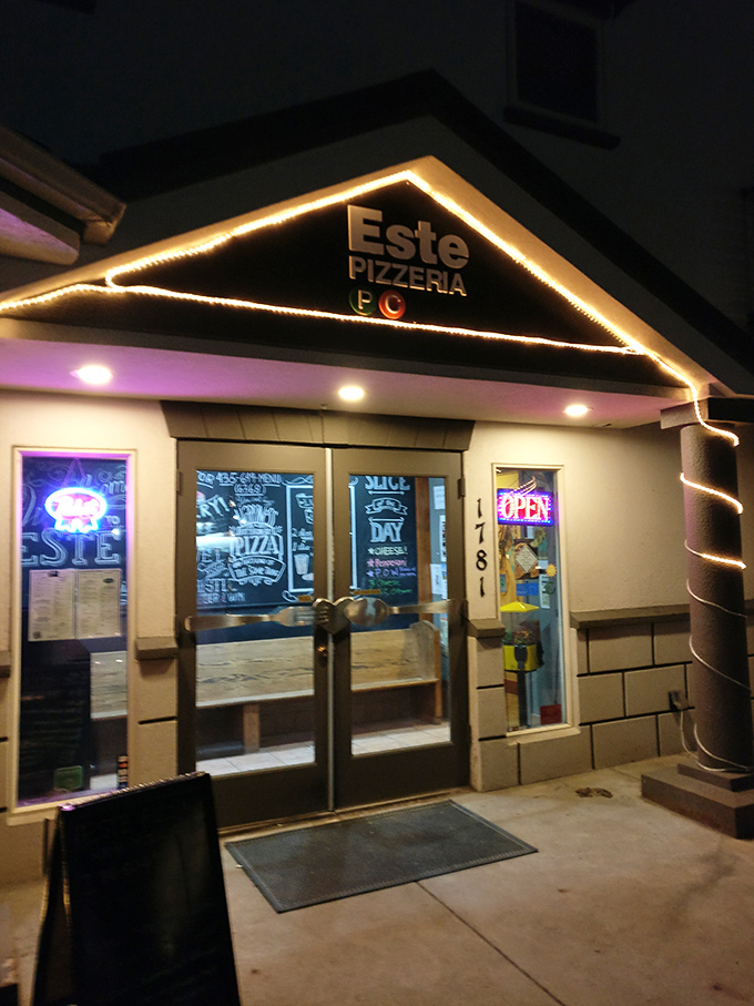 Este's nighttime glow transforms this simple storefront into a cozy pizza sanctuary. Those twinkling lights practically whisper "come inside."