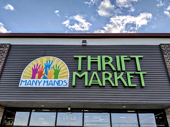 The colorful logo of Many Hands Thrift Market reminds shoppers that their purchases support community efforts both locally and globally.