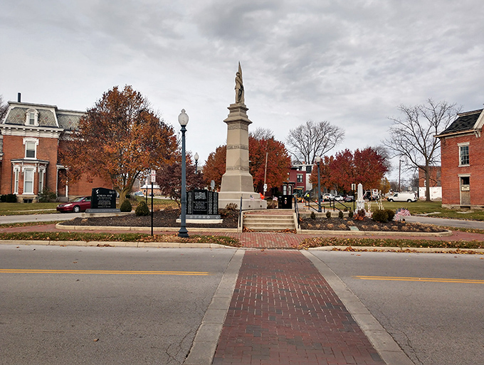 The town's memorial monument stands proudly surrounded by autumn colors, honoring local history in this peaceful community gathering space.