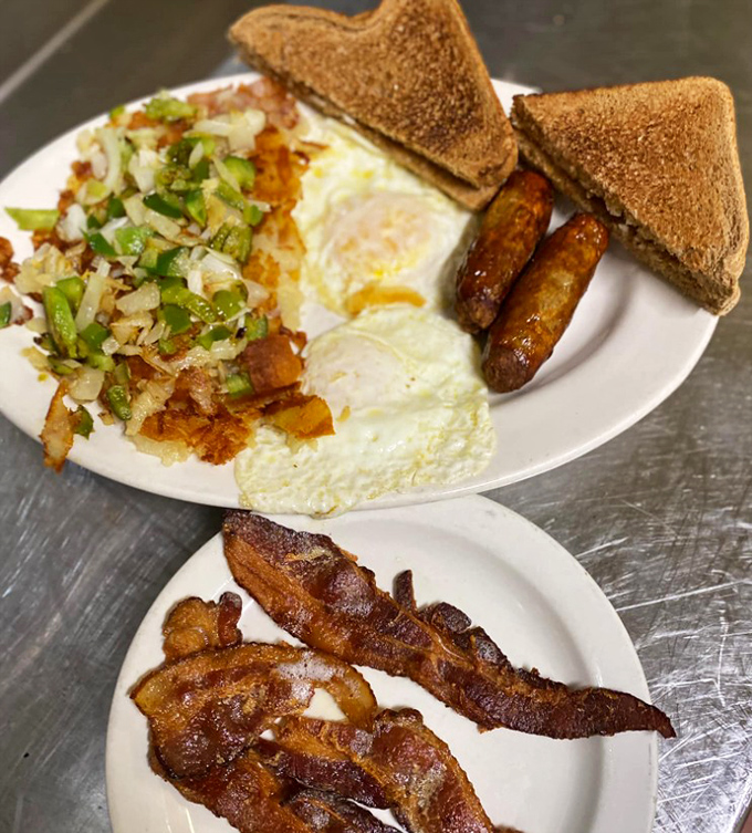 The breakfast trinity: eggs, homefries, and toast, with bacon standing guard. This plate doesn't need Instagram filters—it's naturally photogenic.