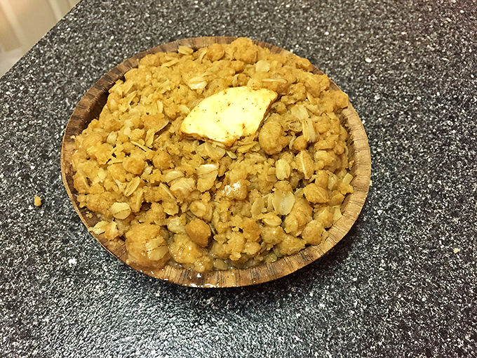 The legendary apple crisp in all its golden, oat-topped glory. That pat of butter slowly melting on top is performing a dessert burlesque show.