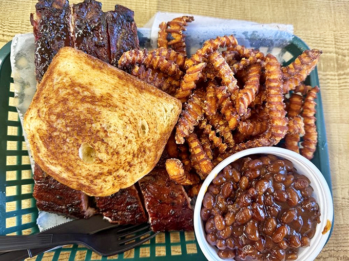 The barbecue trifecta: ribs, toast, and those crinkle-cut fries. Add baked beans swimming in molasses-rich sauce and you've got yourself a plate of pure happiness.