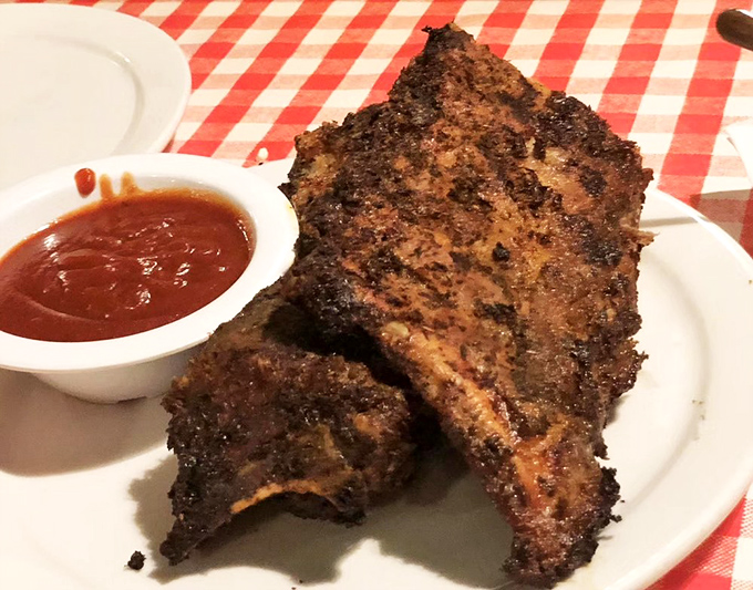 These BBQ ribs have clearly been having a long, intimate conversation with smoke and spice. The sauce glistens like it's telling delicious secrets.
