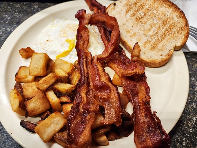 Bacon cooked to that magical sweet spot between chewy and crisp, alongside home fries that could make a potato proud.