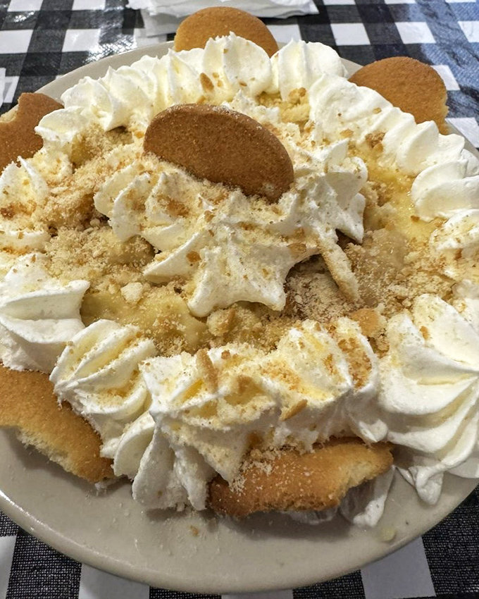 Banana pudding piled so high with whipped cream and cookies, it practically qualifies as architectural engineering meets dessert heaven.