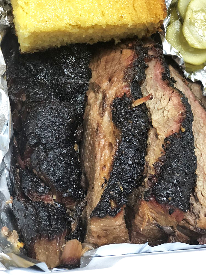 Brisket with a smoke ring so perfect it could be used to teach geometry. The cornbread on top is just showing off.