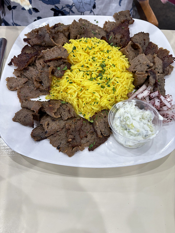 Beef shawarma arranged like a royal crown around golden rice &ndash; proof that sometimes the most regal dining experiences happen on ordinary plates.