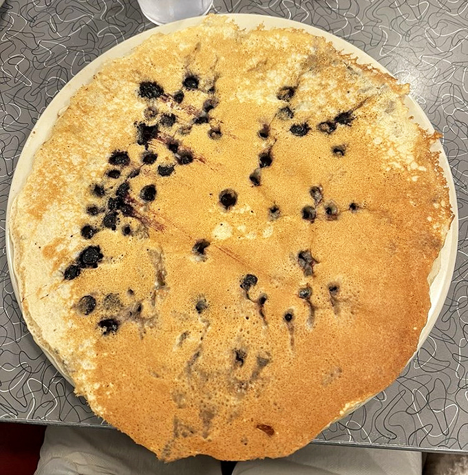 Blueberry pancakes the size of vinyl records, with berries that burst like tiny flavor bombs. Breakfast or dessert? Why choose?