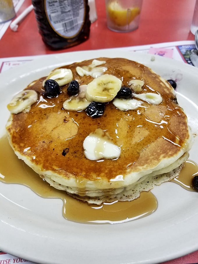 Blueberry pancakes drizzled with maple syrup and topped with fresh fruit&mdash;breakfast's answer to "Why get out of bed today?"