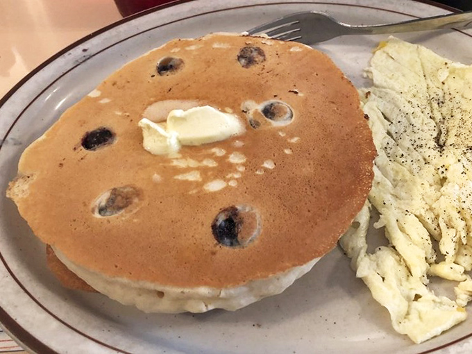 These blueberry pancakes don't just sit on the plate—they command it, with butter melting into those perfect pockets of berry goodness.