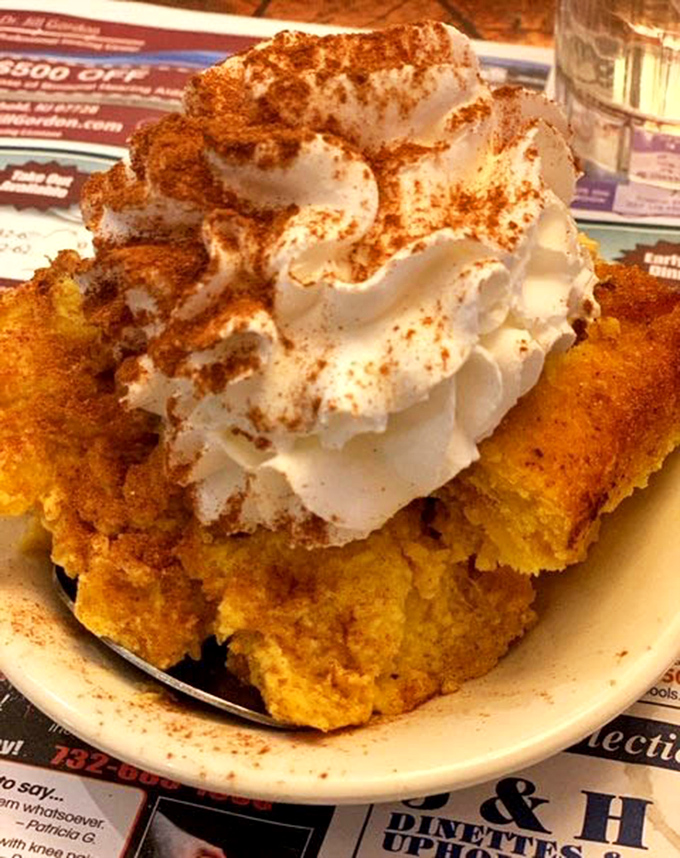 This pumpkin dessert with whipped cream and cinnamon isn't just a treat, it's an autumn festival that decided to settle down on a plate.