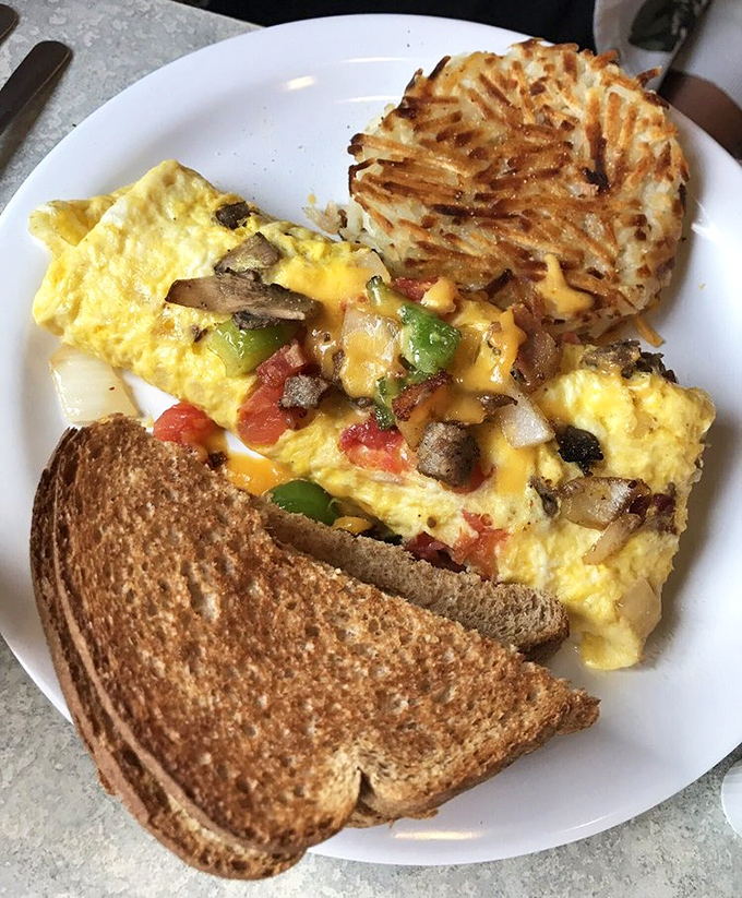 An omelet that's having a very serious relationship with cheese, served with hash browns crisped to golden perfection.