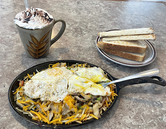 A breakfast skillet that's essentially morning joy in cast iron form – crispy potatoes, melted cheese, and eggs that make hitting the snooze button worth it.
