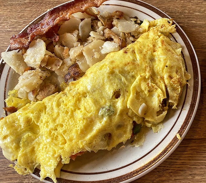 An omelet that's seen things, flanked by home fries that could make a potato farmer weep with pride. This is breakfast with ambition.