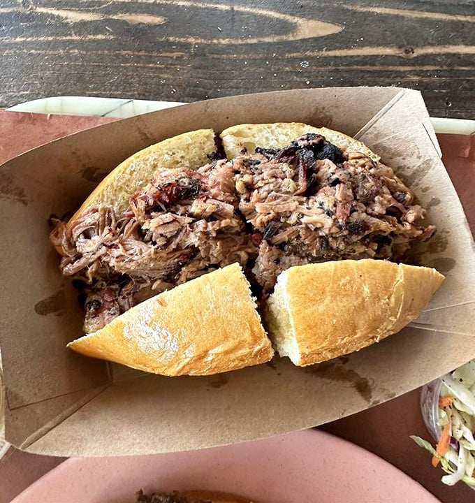 The brisket sandwich – where smoke-kissed beef finds its perfect home between bread. Simple, unpretentious, and absolutely transcendent in its execution.