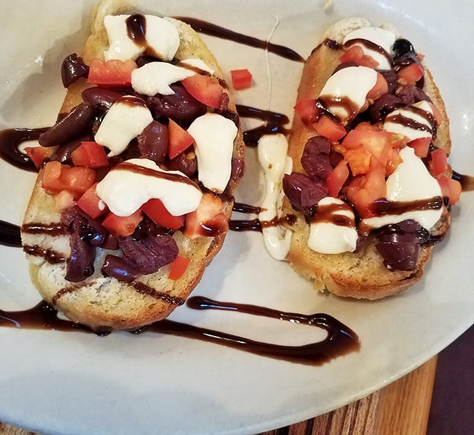 Bruschetta that's dressed better than most people at formal events. Fresh tomatoes, olives, and cheese drizzled with balsamic&mdash;a bread masterpiece.