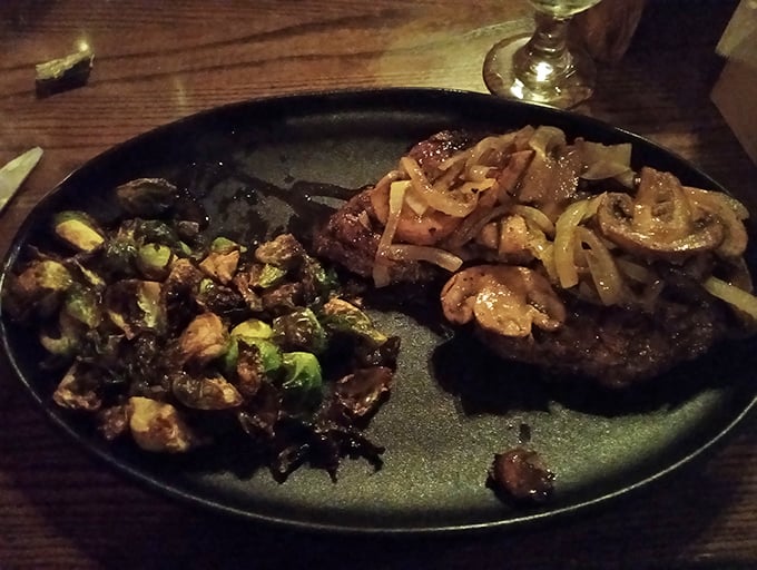 This steak shares the plate with Brussels sprouts and caramelized onions. The vegetables are just there to make the meat look good.