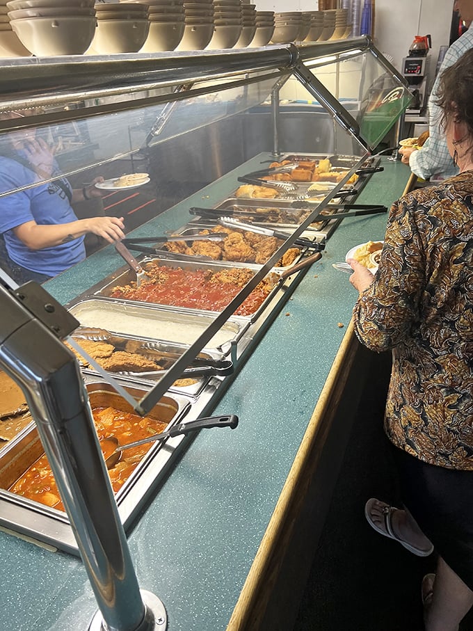 The buffet line stretches like a highway of comfort food possibilities. Each steam tray holds memories waiting to be made.