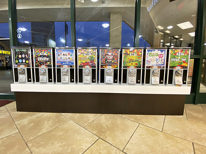 Candy dispensers lined up like a sugary slot machine&mdash;insert coins, turn knob, receive happiness in brightly colored candy-coated form instantly.