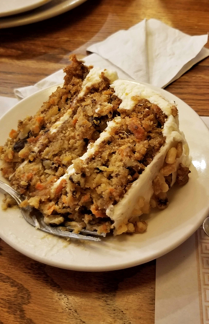 This carrot cake looks like it was baked by someone's grandmother who refuses to share the recipe but always brings it to family gatherings.