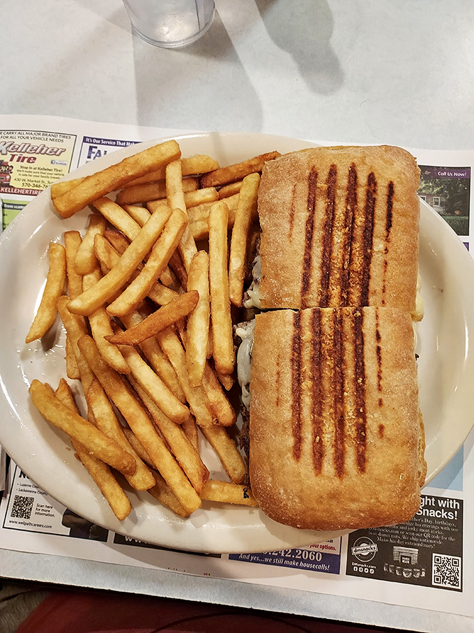 This panini bears the battle scars of a proper grill press, its crispy exterior protecting the melty treasures within. A sandwich with character.