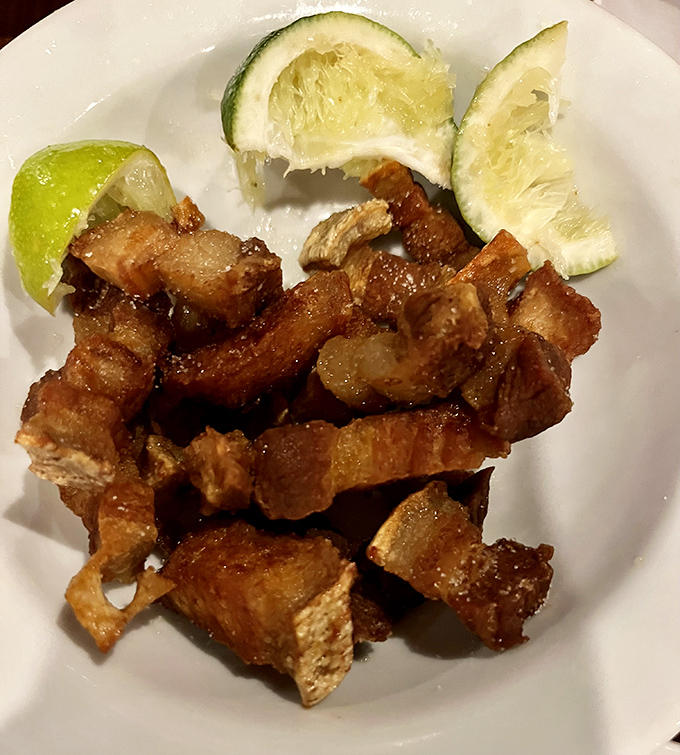 Crispy chicharron that shatters with each bite, served with lime wedges for that perfect acidic counterpoint. Pork perfection, plain and simple.
