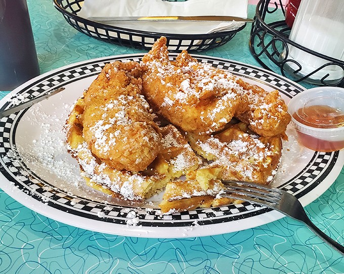 Whoever first decided to put chicken and waffles together deserves a Nobel Prize. That dusting of powdered sugar is like snowfall on comfort food mountain.