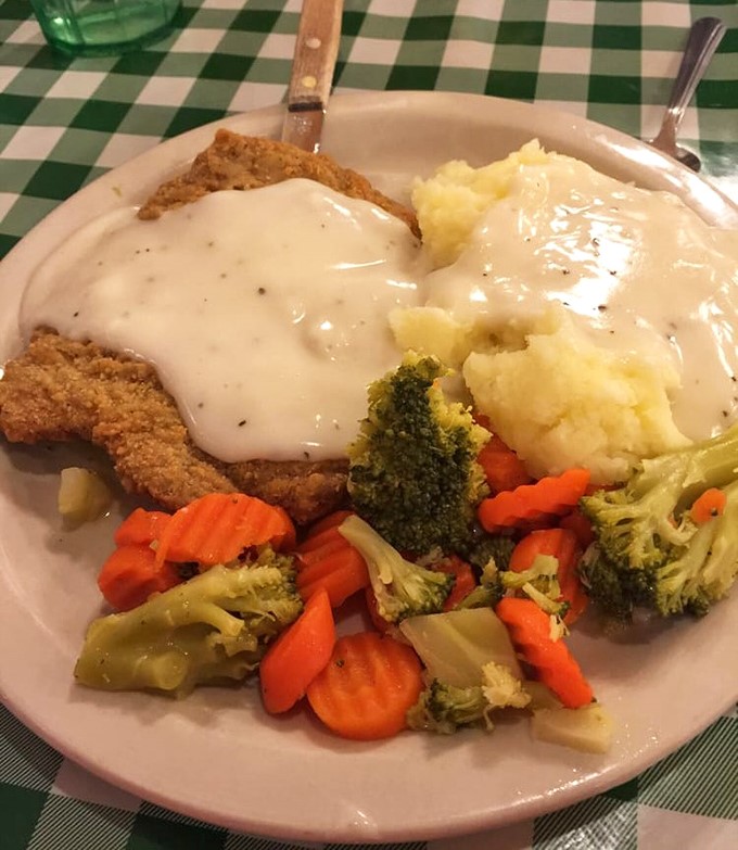 Country-fried steak swimming in peppery gravy alongside vibrant vegetables. Comfort food that hugs your soul while still making room for something green&mdash;balance achieved! 