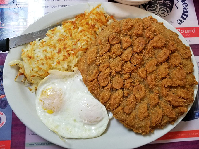 A chicken fried steak that covers the entire plate like it's trying to annex neighboring countries. Oklahoma on a plate.