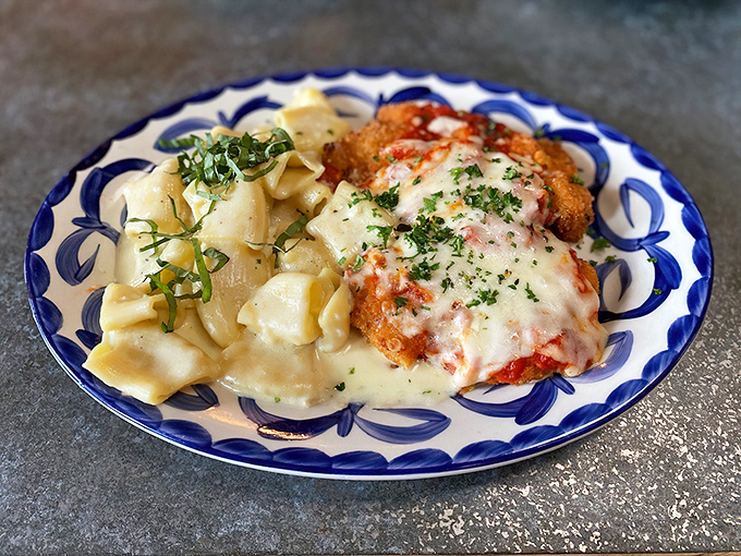 Golden-breaded chicken parm sits beside creamy pasta like they're posing for their own Italian cookbook cover photo shoot.