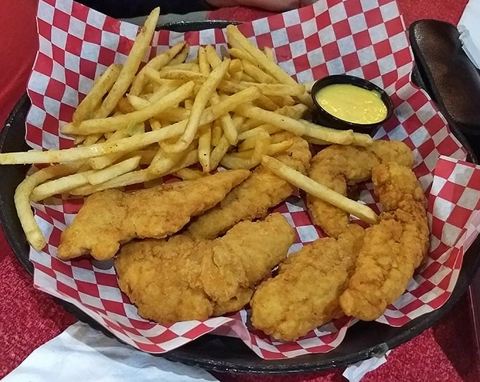 Crispy chicken tenders and fries arrive in a checkered basket, reminding you that some classics never go out of style.