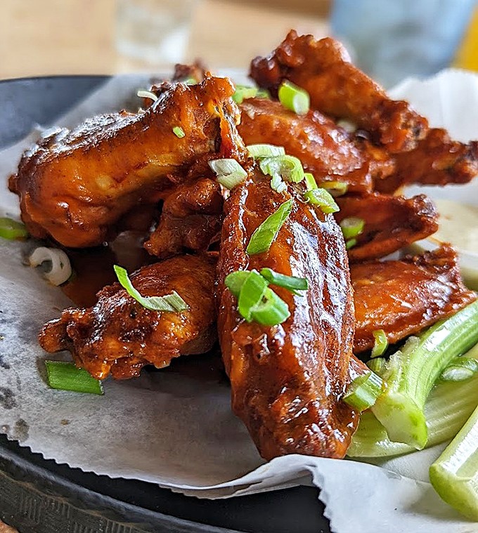 These wings aren't just cooked&mdash;they're transformed. The green onion garnish adds a fresh counterpoint to all that glorious sauce.