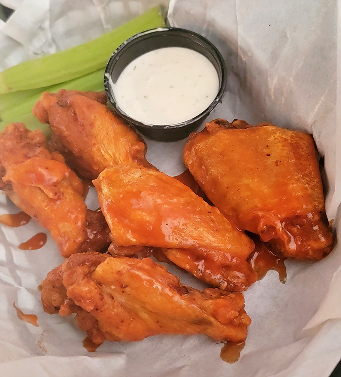 Buffalo wings done right—crispy, saucy, and served with that cooling ranch dip that somehow makes eating fire completely reasonable.