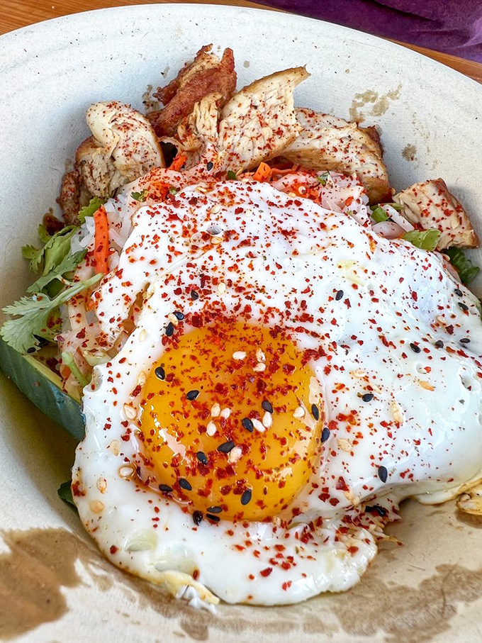 This bowl isn't just breakfast—it's morning poetry. A perfectly cooked egg crowns a throne of savory ingredients, waiting for that satisfying yolk break.