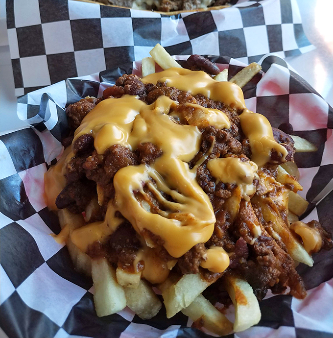 Chili cheese fries creating a beautiful mess that requires both a fork and a positive attitude.
