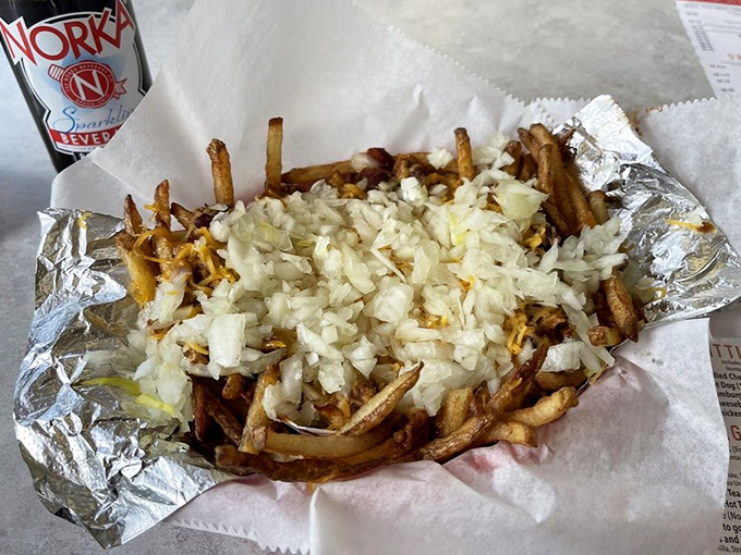 French fries living their best life under a blanket of diced onions&mdash;comfort food that understands exactly what you need after a long day.