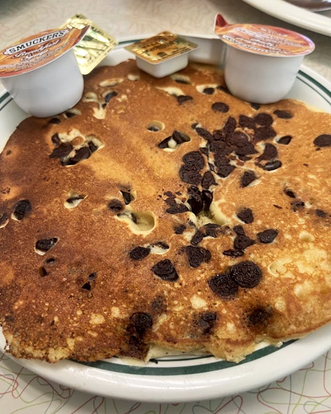 Chocolate chip pancakes: childhood nostalgia served hot off the griddle. The tiny cups of maple syrup stand ready for their ceremonial pour.