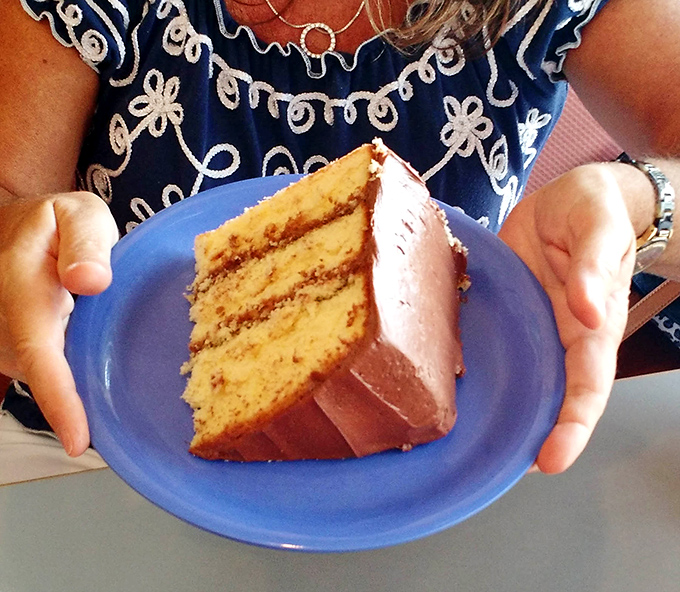 Layer upon layer of golden cake and chocolate frosting &ndash; architectural evidence that someone in that kitchen really, really loves you.