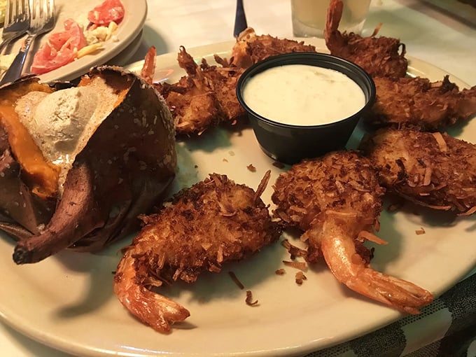 Coconut shrimp that crunch like walking on fresh snow, paired with a baked potato that's having its own moment of buttery bliss.