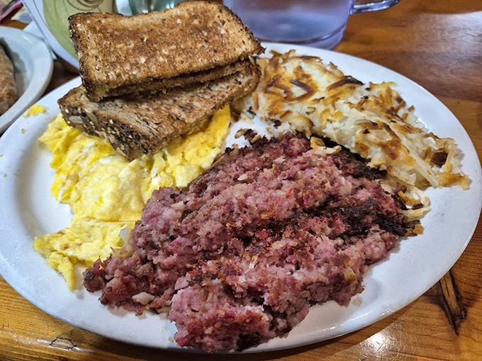 The breakfast trinity: perfectly seasoned corned beef hash, fluffy scrambled eggs, and toast &ndash; simple perfection that needs no explanation.