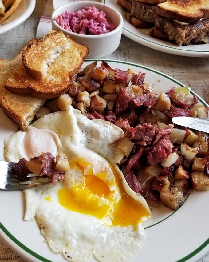 Corned beef hash with eggs that break like sunrise over a delicious landscape. The toast stands by, ready for its supporting role in the breakfast drama.